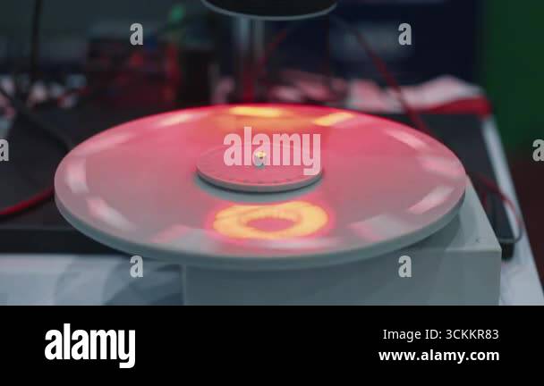 Close up of a spinning industrial machine component with red laser ...