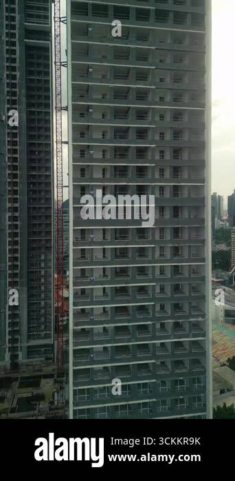 Drone footage of a tall unfinished high-rise building with visible ...