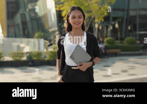 Portrait of young Asian businesswoman holds digital tablet outside ...