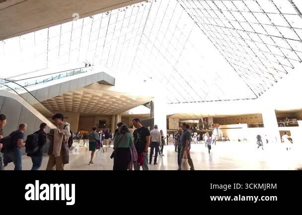 People walking inside Louvre Museum's glass pyramid Stock Video Footage ...