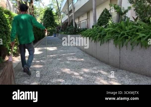 Worker methodically cleaning a path with a broom Stock Video Footage ...