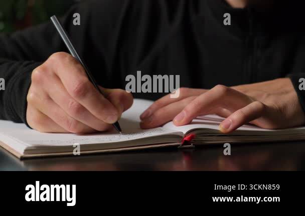 man journaling his thoughts into notebook, because he has some sort of ...