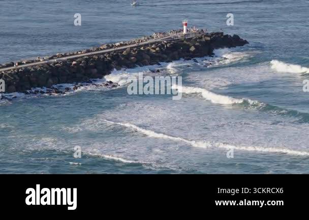 Drone captures waves crashing against a jetty at Gold Coast, Australia ...