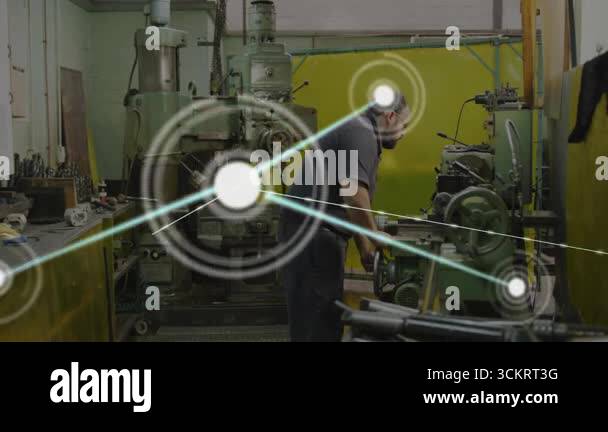 Manufacturing machinist feeding workpiece on lathe, activating network overlay showing sensor ...