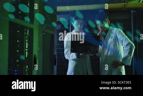Two scientists launching diagnostic software in server room, displaying ...