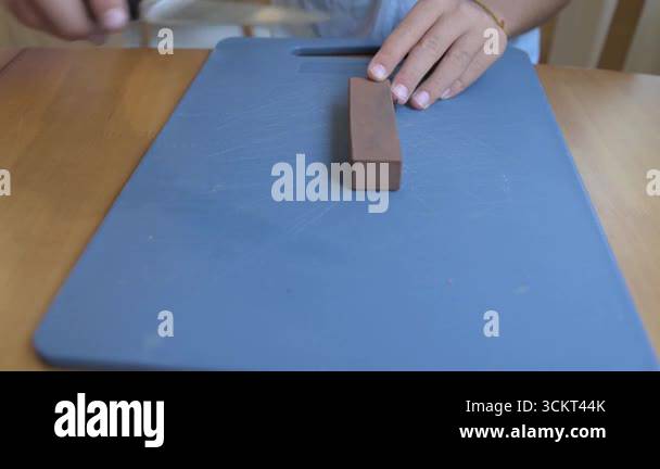 Close-up of hands sharpening knife on whetstone at home. Concept of ...