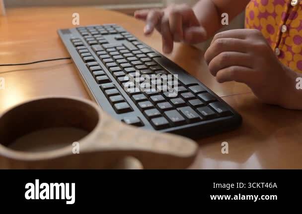 Close-up of hands typing on a black computer keyboard with Cyrillic ...