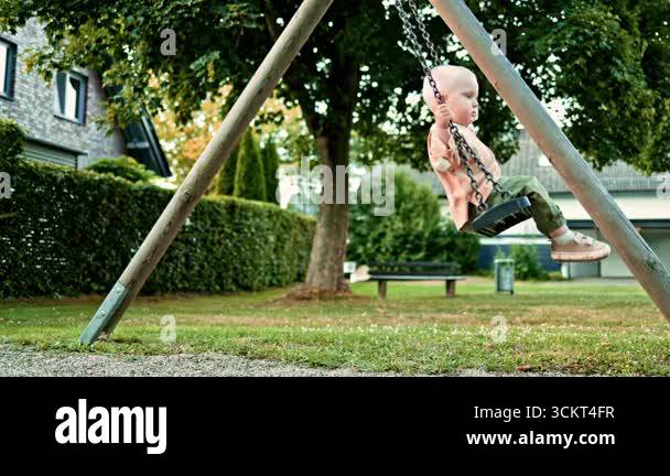 Happy boy swings on a swing on a playground in the park. The child has ...