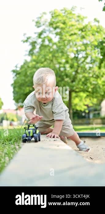 Cute toddler playing in the sandbox on the playground. Child digging ...