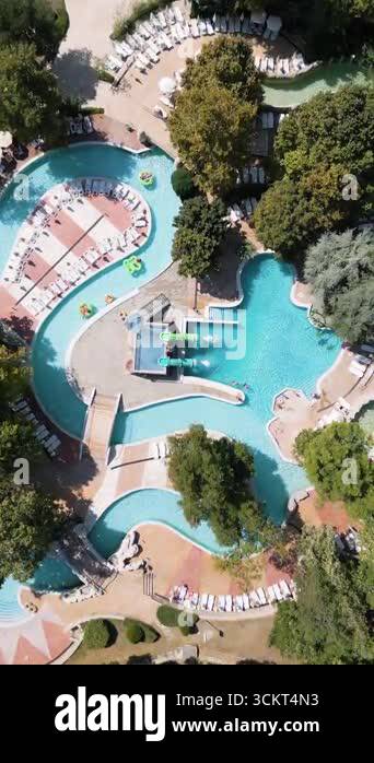 Aerial view of a relaxing water park with interconnected pools, lazy ...