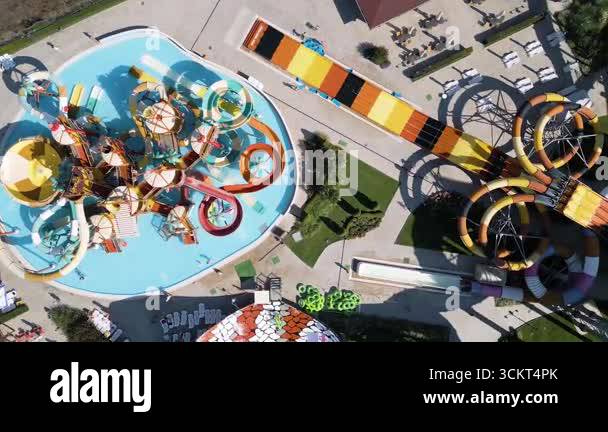 Aerial footage of a vibrant water park with colorful slides, lazy river ...
