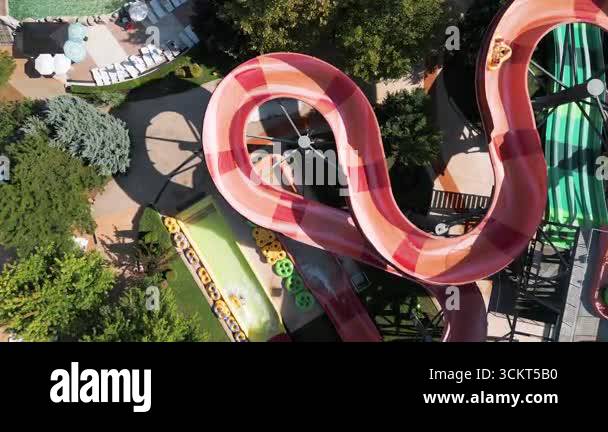 Aerial view of colorful twisting water slides with people riding ...