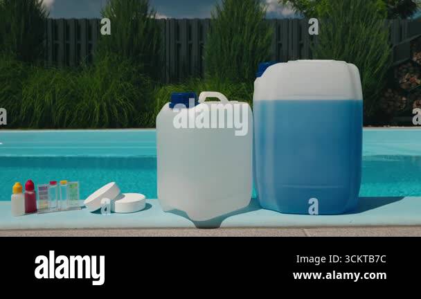 Chlorine canisters, test kits, and tablets placed by a backyard pool ...