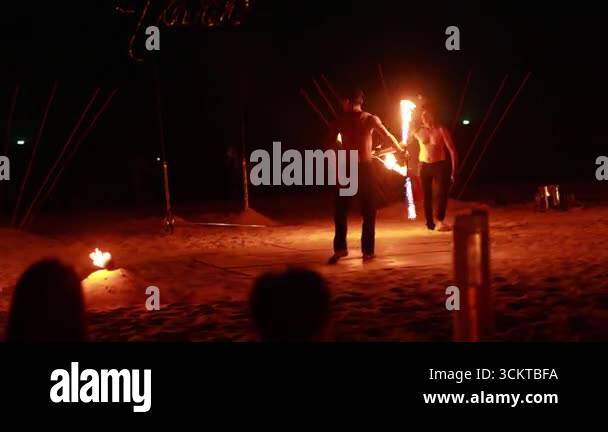 A captivating fire twirling act on a sandy beach in Phuket, Thailand ...
