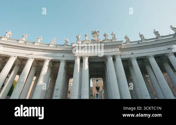 St. Peters Square colonnade with statues and columns under clear sky in ...