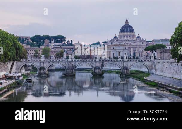 Rome from evening to night with city lights reflecting in Tiber River ...