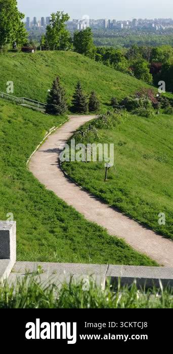 Verdant grassy slopes gently rolling around winding pathway, revealing ...
