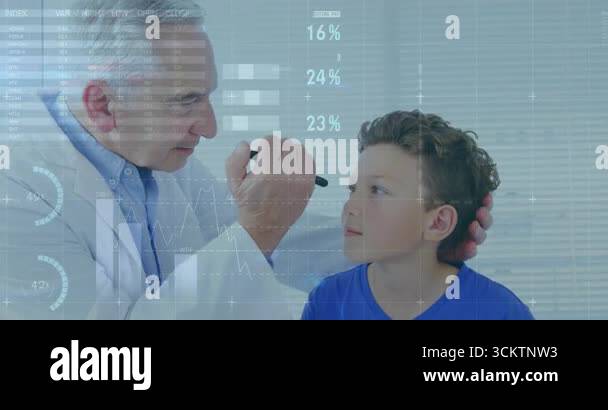 Doctor raising penlight to boy's eyes in clinic for eye test with ...