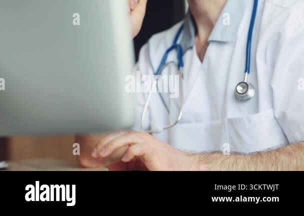 Portrait of doctor sitting at monitor of computer in doctor s office ...