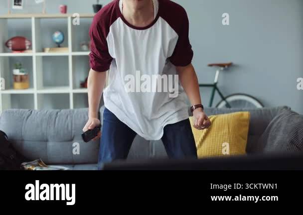 Handsome chinese man with glasses dancing hold remote at home looking ...