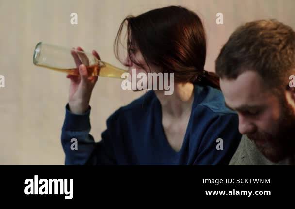 Unhealthy drunk alcoholic man and woman with a beer sit on sofa sleep ...
