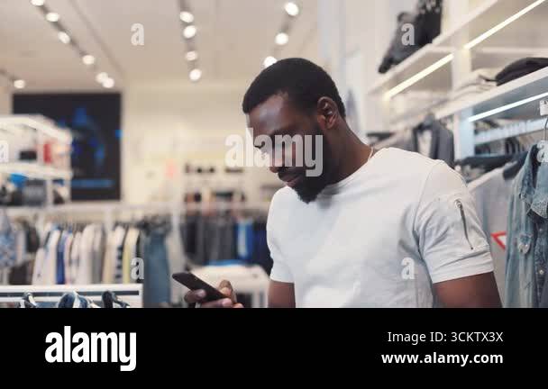 Handsome african american young man using phone texting message stand ...