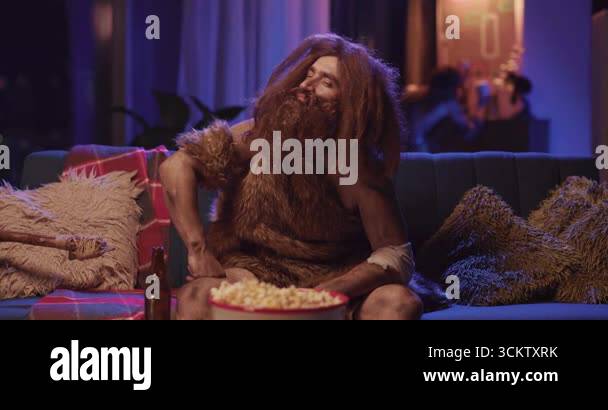 Prehistoric time traveler wild caveman in animal fur pising at camera ...