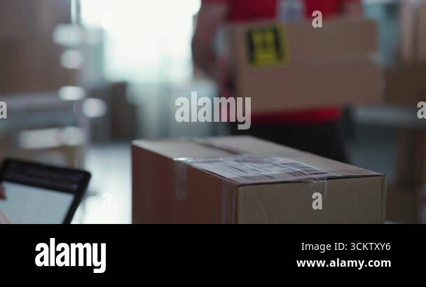 Warehouse worker in post office department receiving parcel boxes and ...