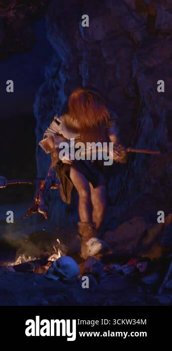 A caveman figure holding a weapon stands boldly near a flickering fire ...