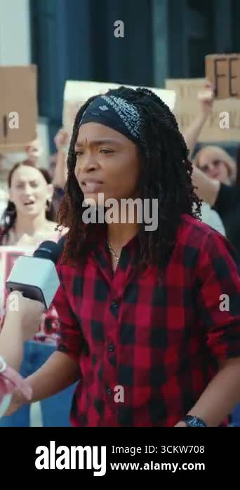 A passionate activist stands before the assembled crowd at a vibrant ...