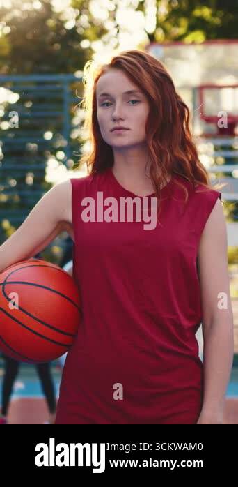 A female athlete poses confidently with a basketball, effectively ...