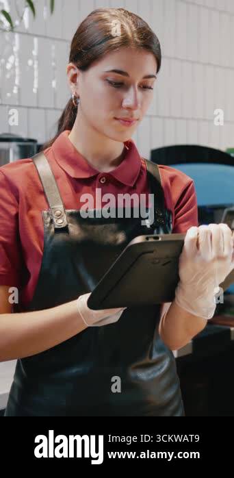 A determined young woman diligently working in a bustling cafe ...