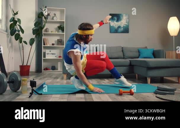 Joyful retro fitness man stretching balancing on one leg on exercise ...