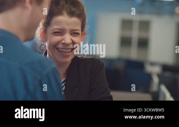 Pretty girl with neat hairdo and in casual clothes laughing loudly at ...