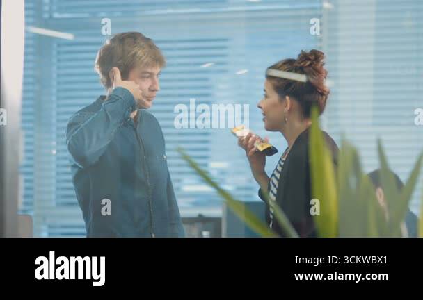 Two young employees communicating in office. Guy and girl discussing ...