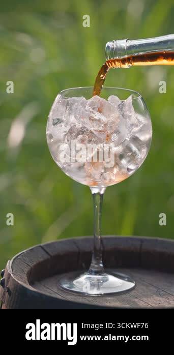 fresh refreshing aperol spritz cocktail flows into a glass from a ...