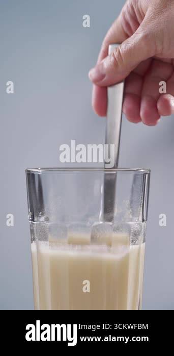 human hand mixing protein powder in glass of water. whey sports ...
