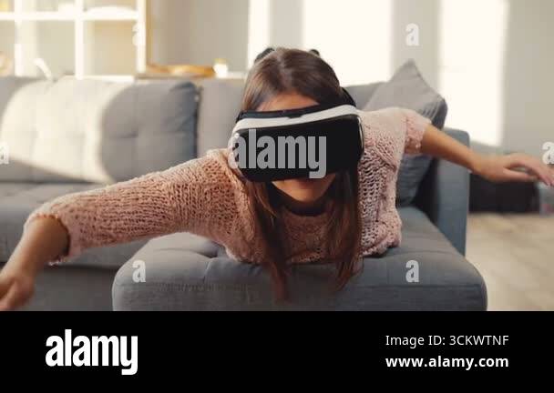 Attractive young brown-haired woman in pink sweater laying on couch and ...