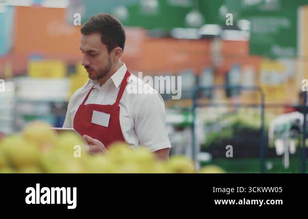 Portrait seller man use tablet computer in supermarket look camera ...