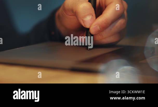 A close-up of a hand writing on a digital tablet, capturing the essence ...