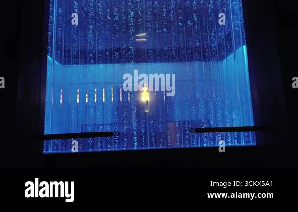 Glowing light illuminating behind cascading blue water streams Stock ...