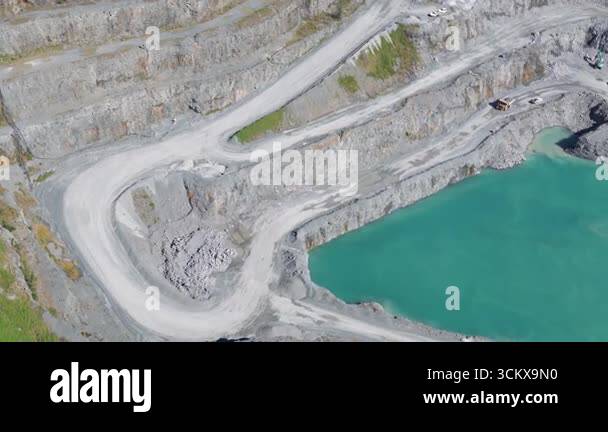 Aerial footage of a quarry with vibrant turquoise water, showcasing ...