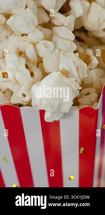 Animation of golden confetti over box of popcorn. popcorn day and ...