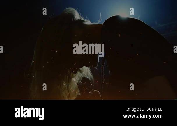 Singer raising head, lifting microphone under spotlight, scattering ...