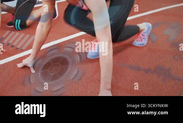 Two women responding to start signal while sprinting track with ...