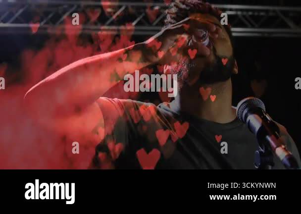 Performer at mic under lights downing shot smashing glass cheering in ...