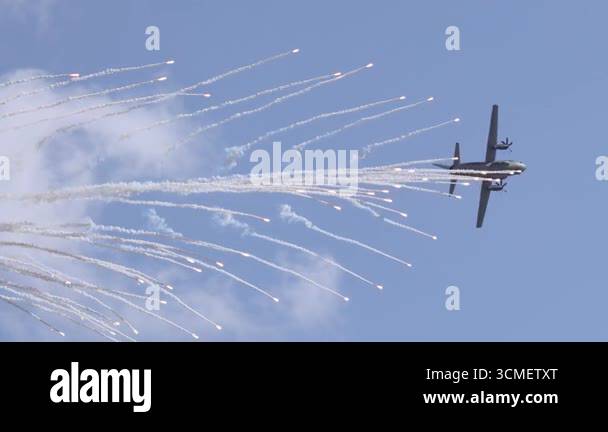 A plane releases flares in a clear sky, showcasing dynamic aerial ...