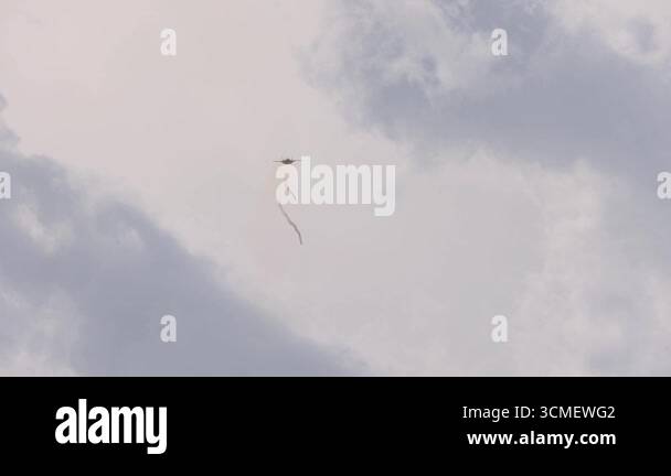 An F-35 jet releases flares during an aerial display against a cloudy ...