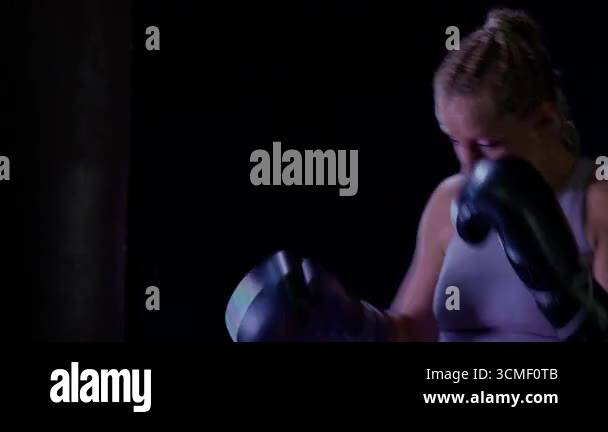 Motion blur, woman pro fighter trains his punches, hard training in the ...