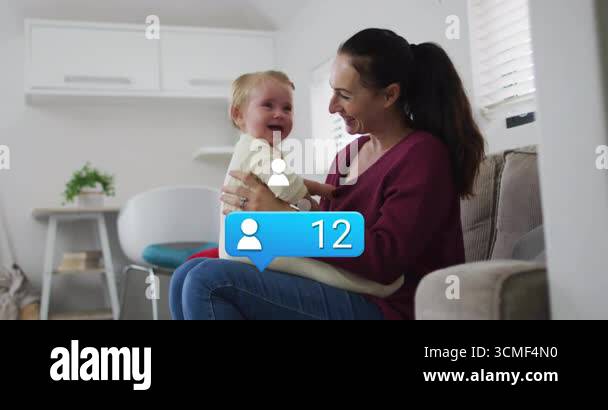 Mother rocking baby on couch and initiating animated social media ...